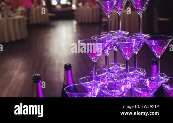 Glasses with alcoholic beverages in the pyramid, filling and pouring ...