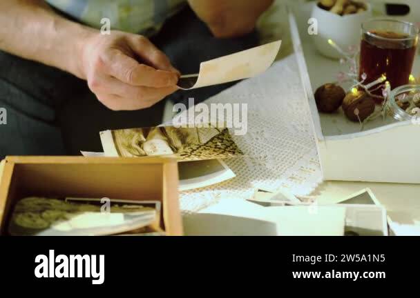 an elderly man looks through his old photographs of 1960-1965, the ...