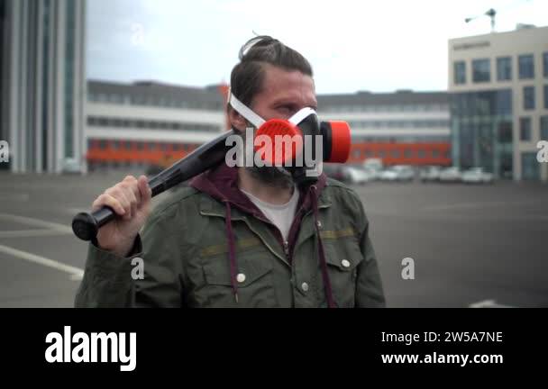 Strange middle aged man in parking with respirator and baseball bat on ...