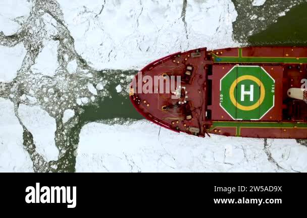 Aerial above epic huge steel ship breaks ice by bow of ship and floats ...