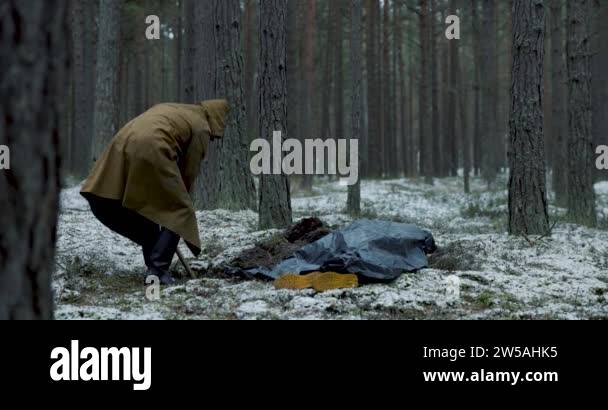 serial killer digs a grave in the woods at winter to hide the corpse ...