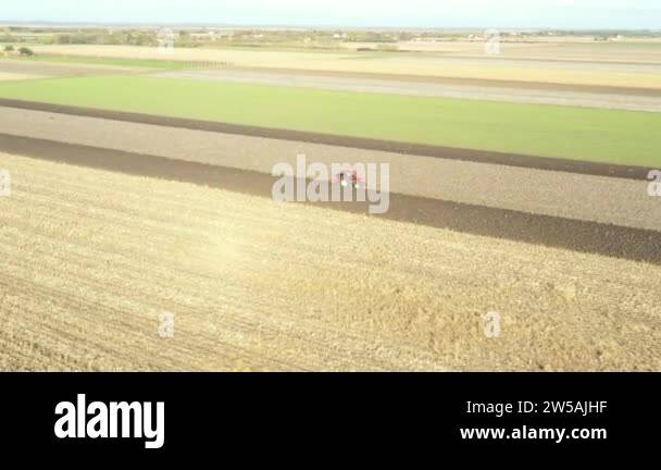 Dolly move orbit shot of tractor as plowing the ground on cultivated ...