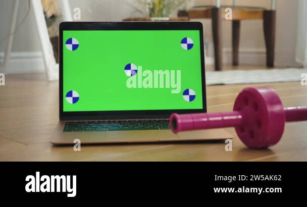 Close-up of laptop green screen monitor with pink dumbbell lying on the ...