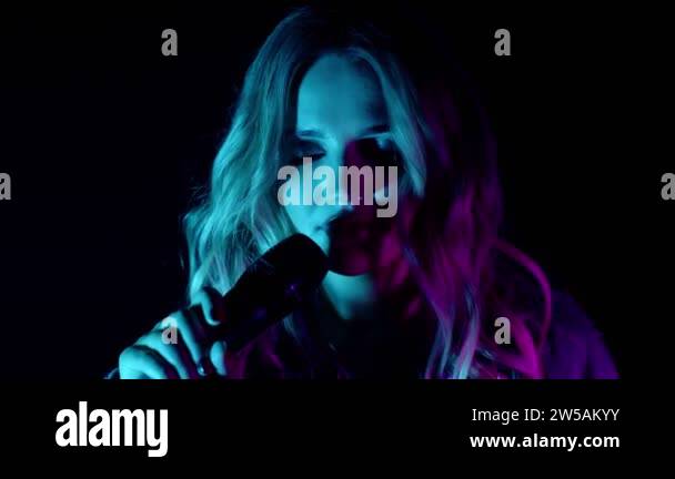 Live vocal performance of singer in darkness, vocalist cute girl in ...
