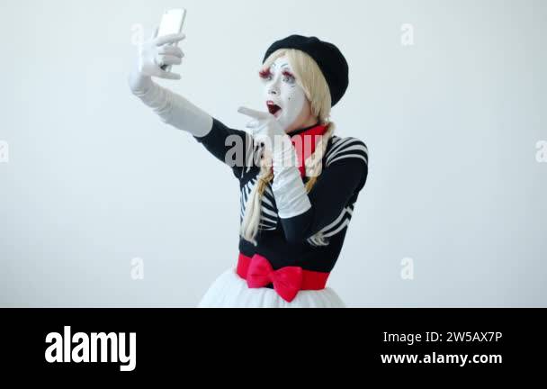 Female mime artist taking selfie with smart phone camera posing with ...