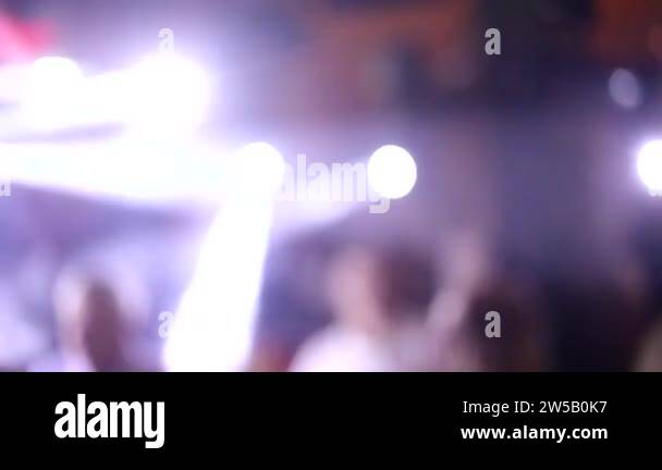 Neon lights on the dance floor. Slow time. Blurry bokeh. People are ...