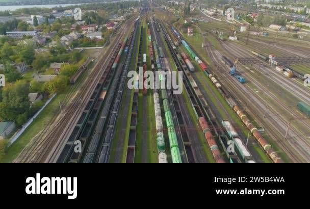 Freight trains stand at the railway junction top view. Fly over a large ...