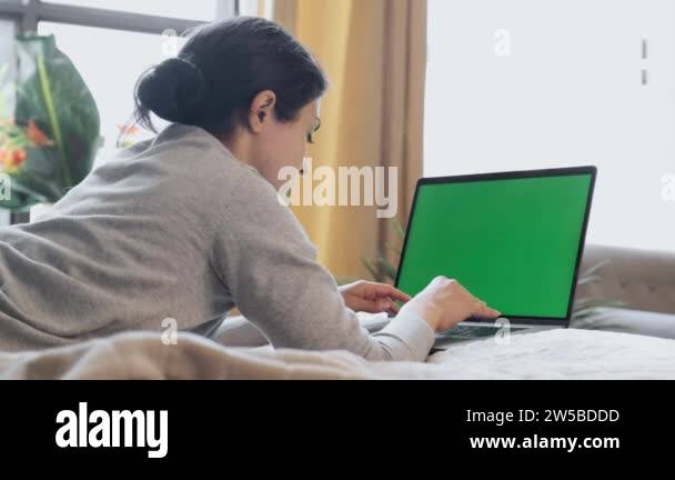 Young woman relaxing at home on the couch and using laptop computer ...