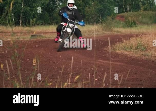 Slowmo shot of men in helmets and gear riding motorcycles and taking ...