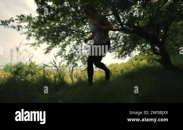 Girl runs between trees, young girl jumps over a tree branch, young ...