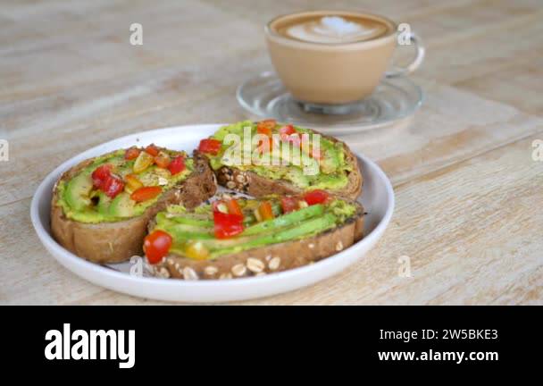 Three toast with mashed and sliced avocado and tomatoes on whole grain ...