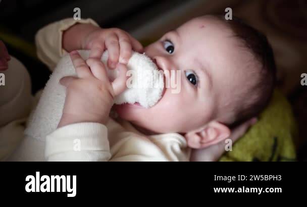 happy Little baby boy playing with his legson mother hands. Bite and ...