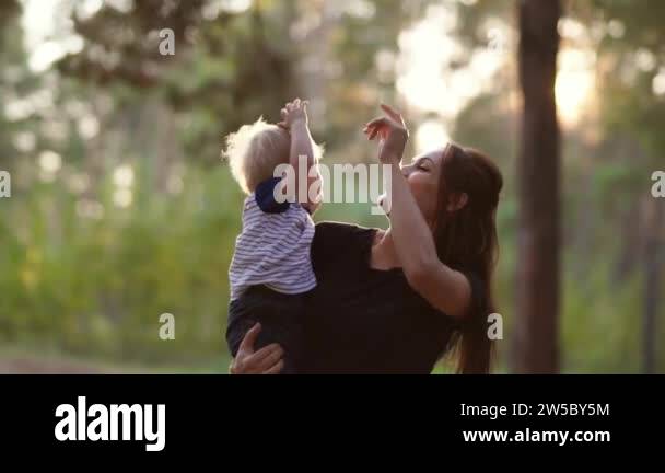 Mom holds her son in her arms and points to him to look up. A happy ...
