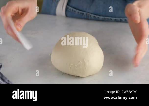 Beautiful female hands in a professional kitchen prepare flour dough ...