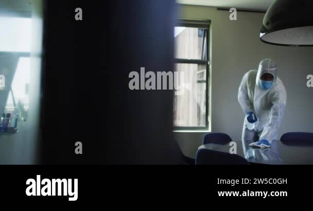 Team of health workers wearing protective clothes cleaning the office ...