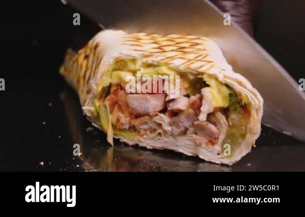 Professional chef is making shawarma at fast food cafe, close-up. He is ...