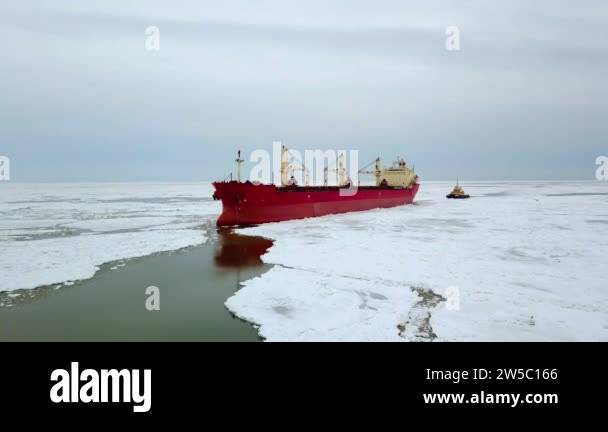 Aerial above epic huge steel ship breaks ice by bow of ship and floats ...