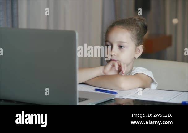The younger student sits at home at the computer, studies, listens to ...