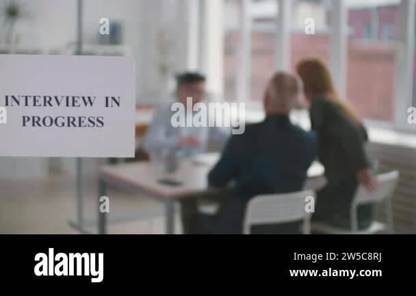 Interview in progress sign printed on paper hanging on glass wall in ...
