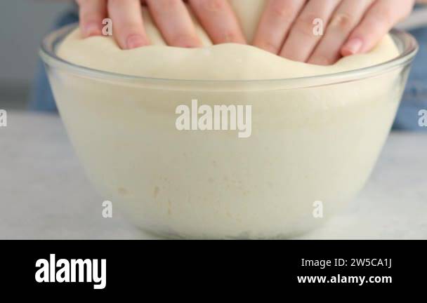 Beautiful female hands in a professional kitchen prepare flour dough ...