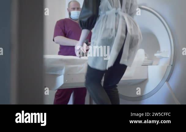 The doctor conducts an MRI or PET scan of a patient in a modern clinic ...