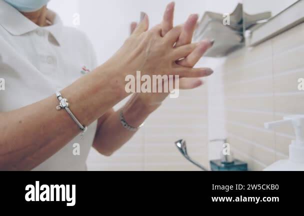 female lab worker washes her hands before taking blood. Woman washing ...
