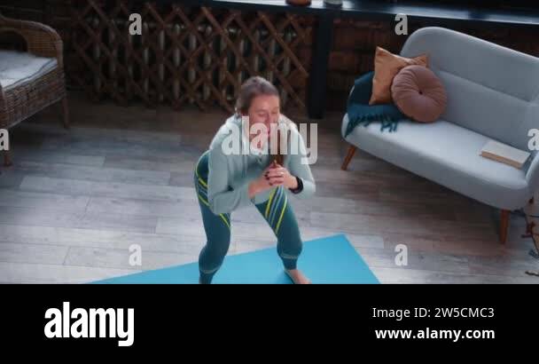 Zoom out on young happy Caucasian fitness coach woman leading workout ...