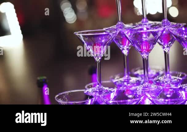 Glasses with alcoholic beverages in the pyramid, filling and pouring ...