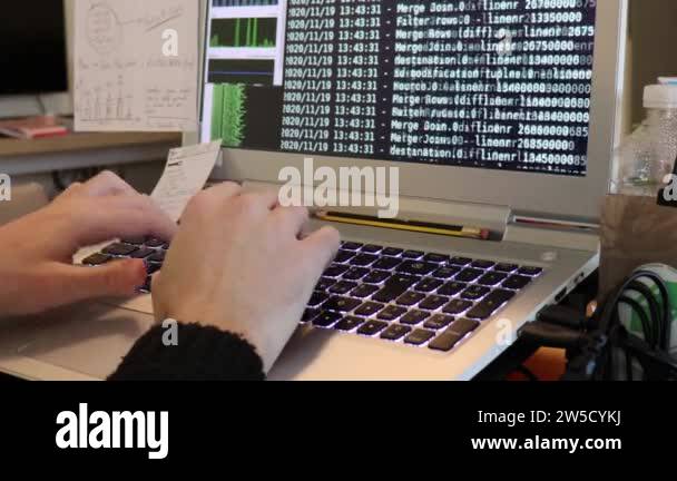 A hacker man writes the green code for an attack. Program a virus with ...