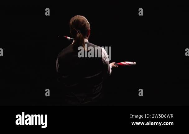 Camera rotates around concentrated man professionally juggling and ...