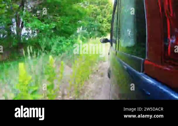 The car drives off-road in the wild before sunset. The camera is ...