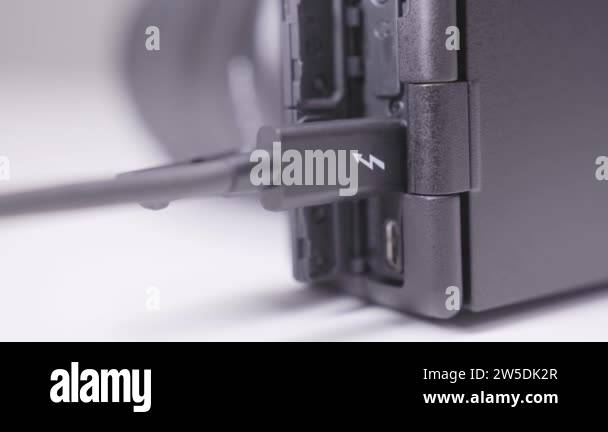Close-up of wired charging of black electronic device. Action. Charging ...