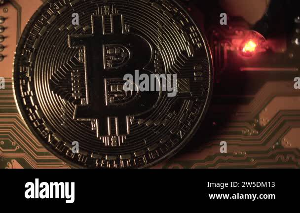 one gold coin with the bitcoin symbol on electronic circuits on the computer motherboard. A ...