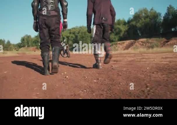 Tracking with rear view of unrecognizable male riders in full gear and ...