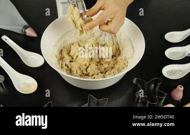 Woman hands are taking off dough from mixer blades. Process of making ...