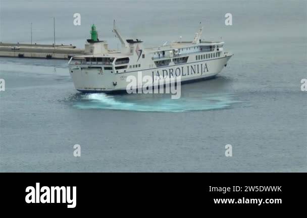 Ferry boat maneuvers to dock at the Split City port. Ferry boat ...