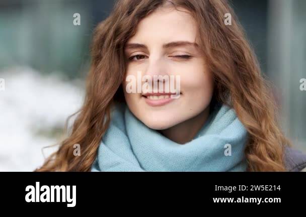Portrait attractive curly woman winking eye and smiling into camera ...