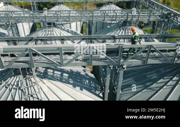 Engineer servicing and inspecting large grain storage containers. An ...