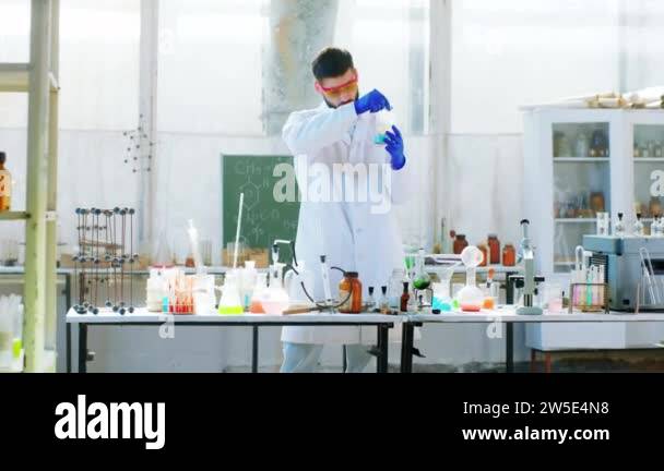 Chemical reaction in a biotechnology laboratory man using some blue liquid to make a experiment ...