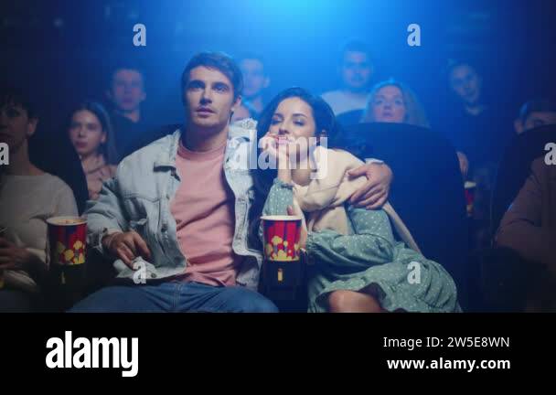 Love couple hugging in movie theater. Happy guy kissing woman in cinema ...