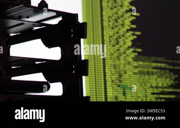 Yellow computer software code moving on a black monitor reflect on glass. Abstract computer ...