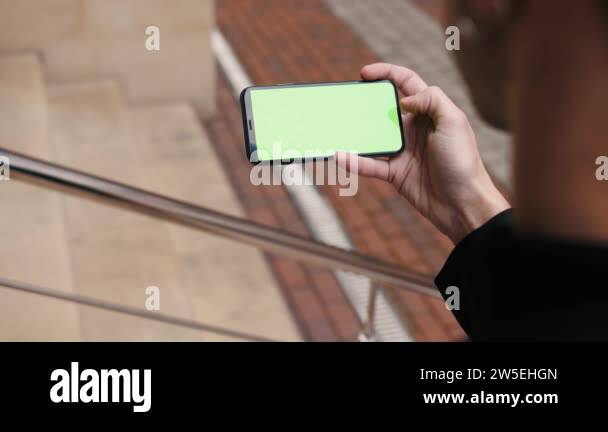 Male hand horizontal keeping touch screen smart phone urban city mock ...