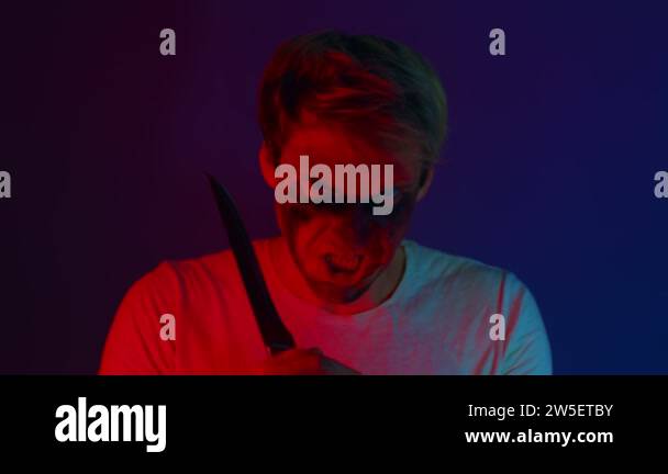 Angry man, maniac or crazy in a dark room. Portrait man with a knife ...