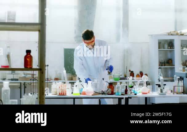 In the chemistry laboratory tall man scientist working on his project ...