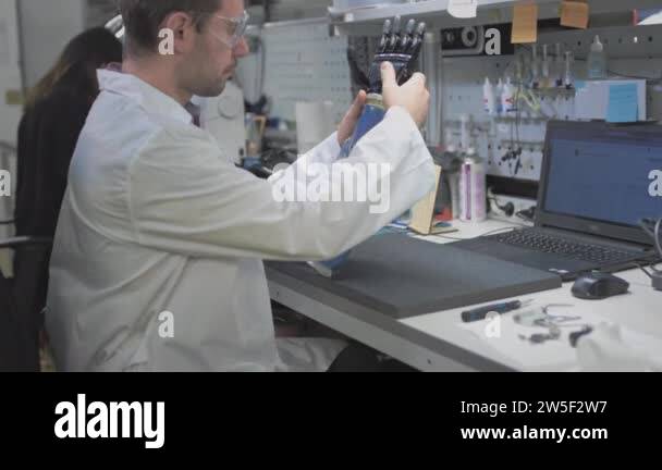 A scientist engineer creates or diagnoses a robotic arm prosthesis ...