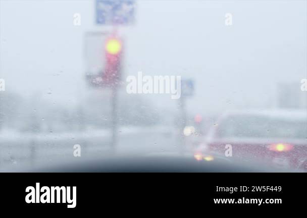 Blurred traffic light background. Rain falling on car windshield view ...