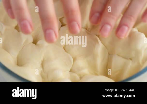 Beautiful female hands in a professional kitchen prepare flour dough ...