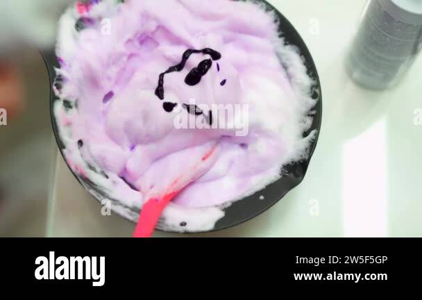 a mixture for dyeing hair white, white foam, blue drops of dye is mixed ...