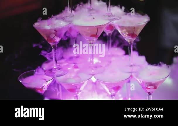 Glasses with alcoholic beverages in the pyramid, filling and pouring ...