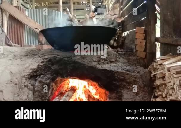 Traditional process of making palm sugar, cooking raw palm extract on ...
